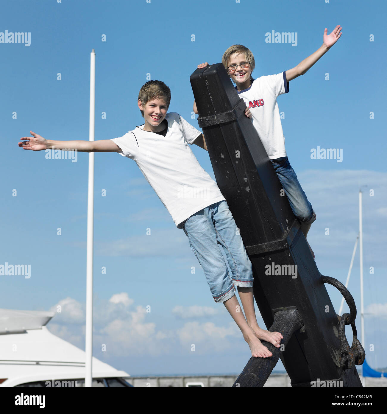 Boys climbing on pier Stock Photo - Alamy