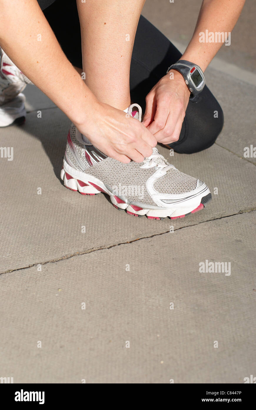 Runner tying her shoe Stock Photo - Alamy