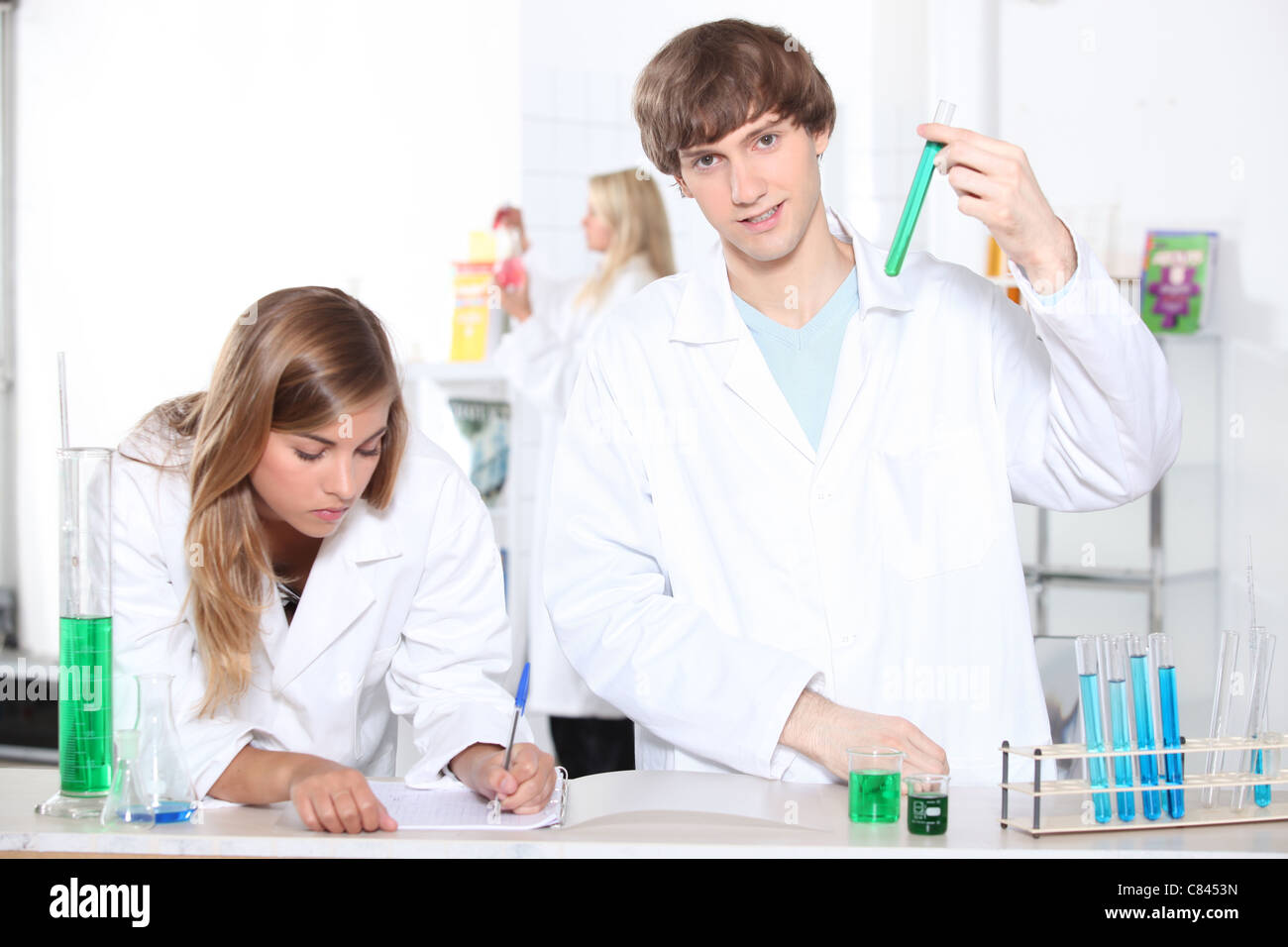 Students in a chemistry class with test tubes and other lab equipment ...