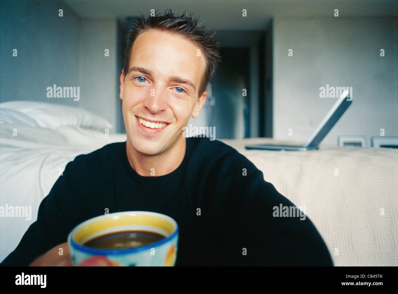 Man drinking cup of coffee in bedroom Stock Photo - Alamy