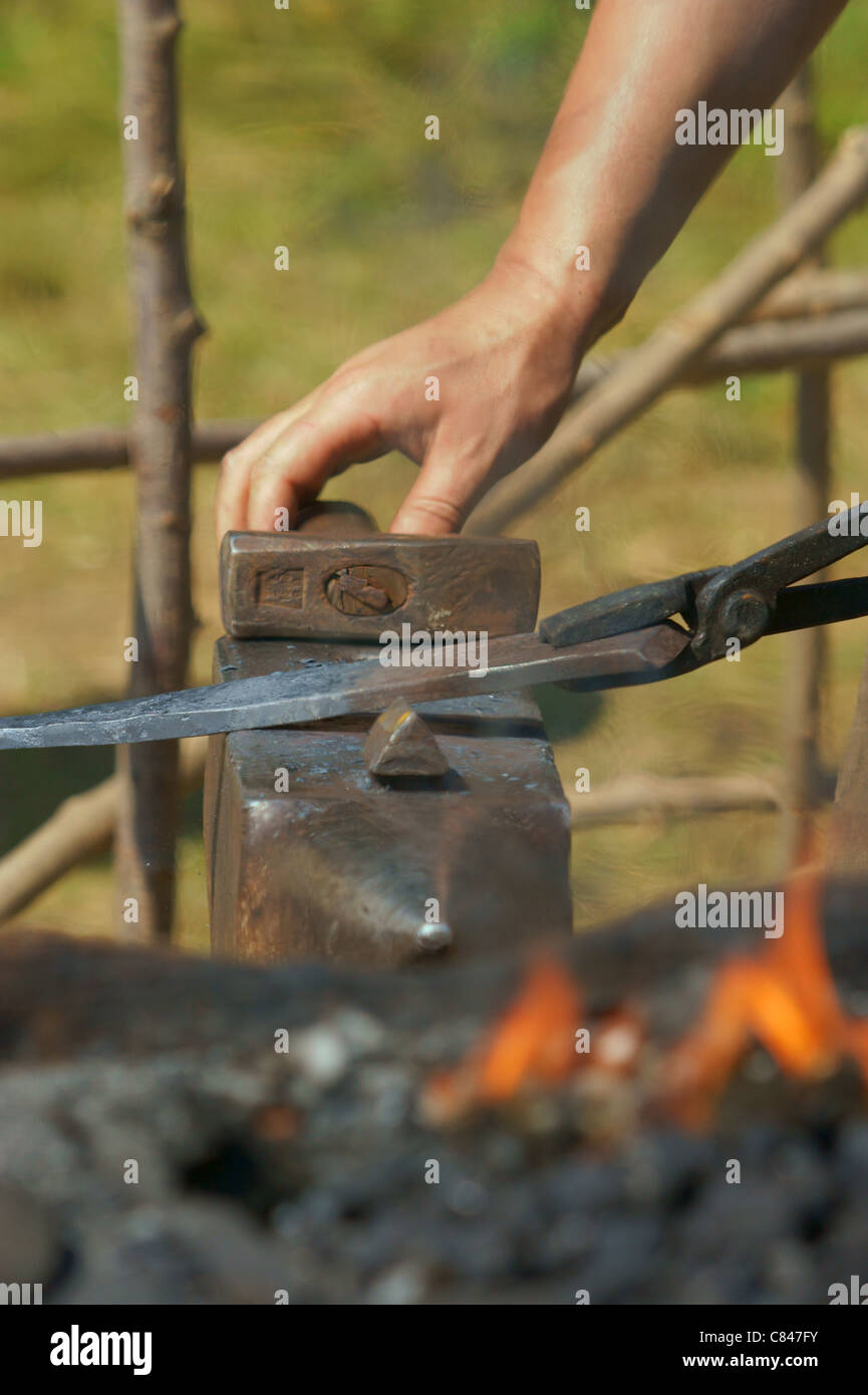 Hammering glowing steel - to strike while the iron is hot Stock Photo ...