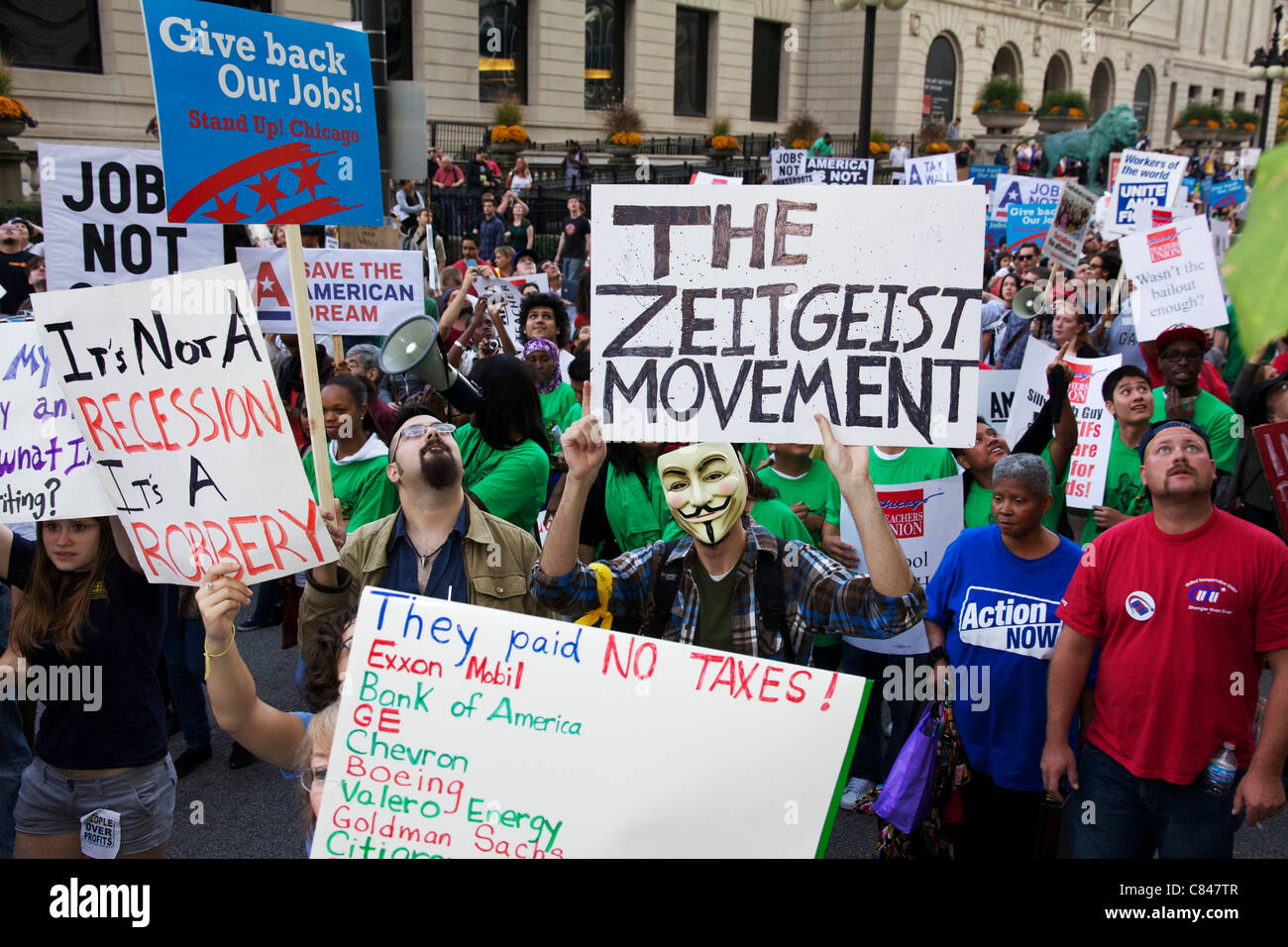 Protesters marching on Michigan Avenue, one wearing Guy Fawkes mask ...