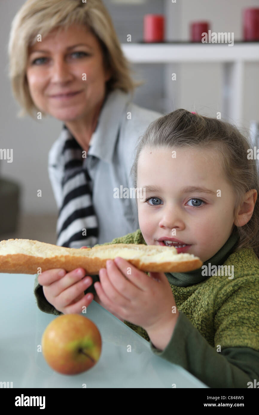 Little girl eating bread toast Stock Photo - Alamy