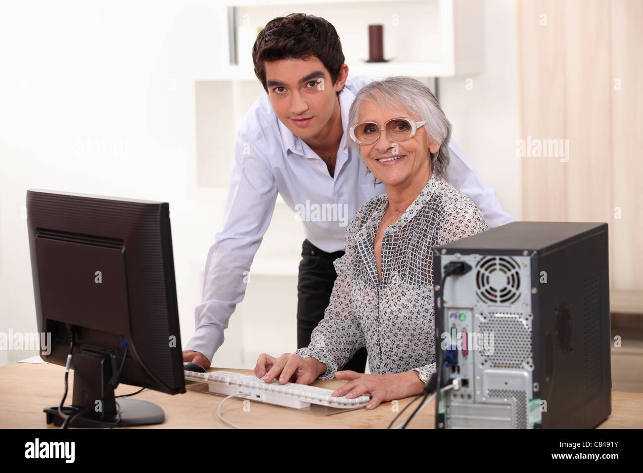 Young man and older woman using a computer Stock Photo - Alamy