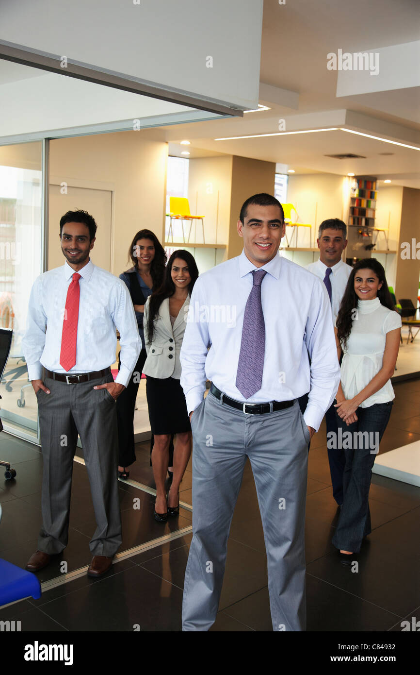 Smiling Hispanic business people standing together in office Stock ...