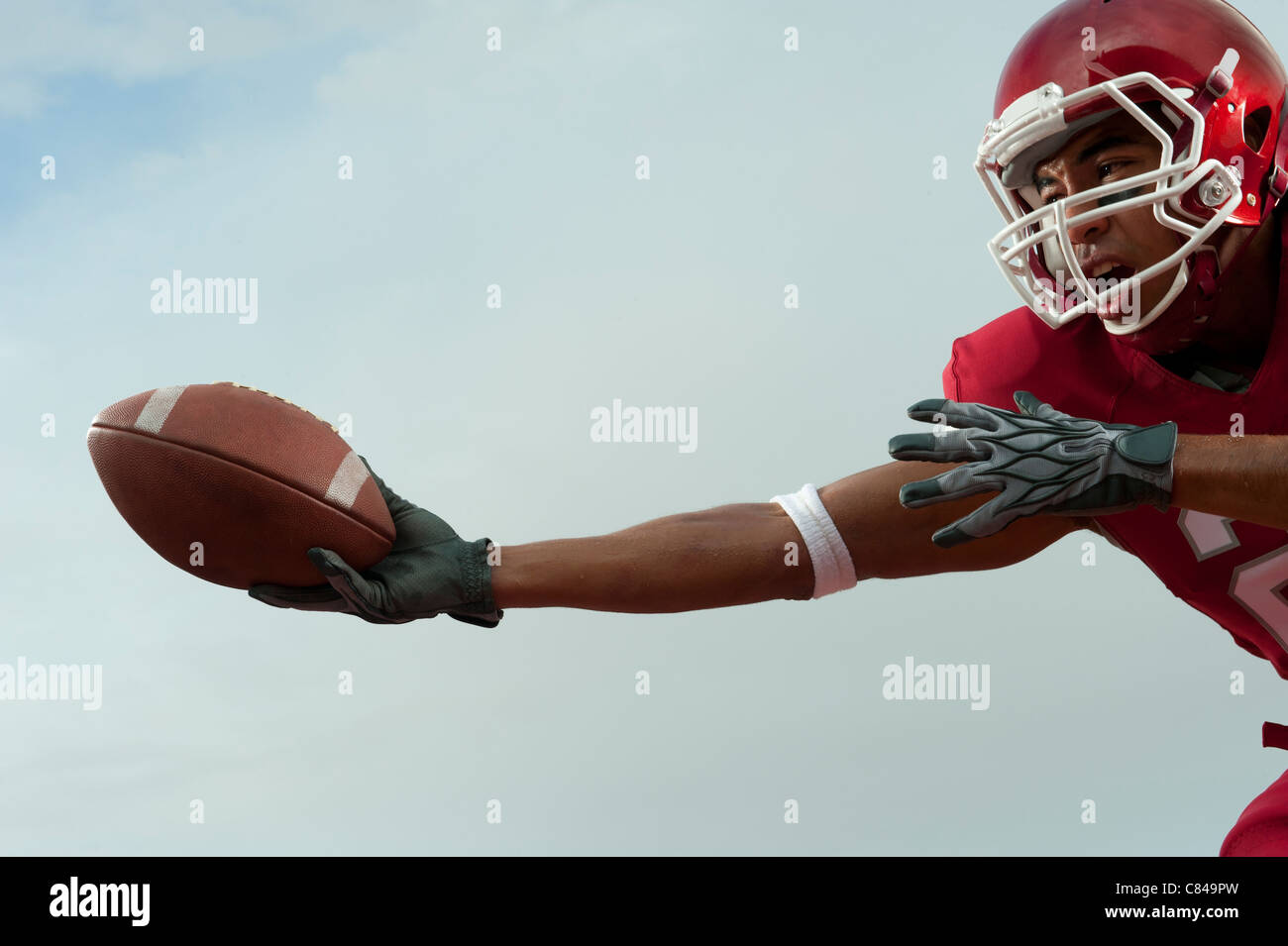 Black football player catching football Stock Photo - Alamy