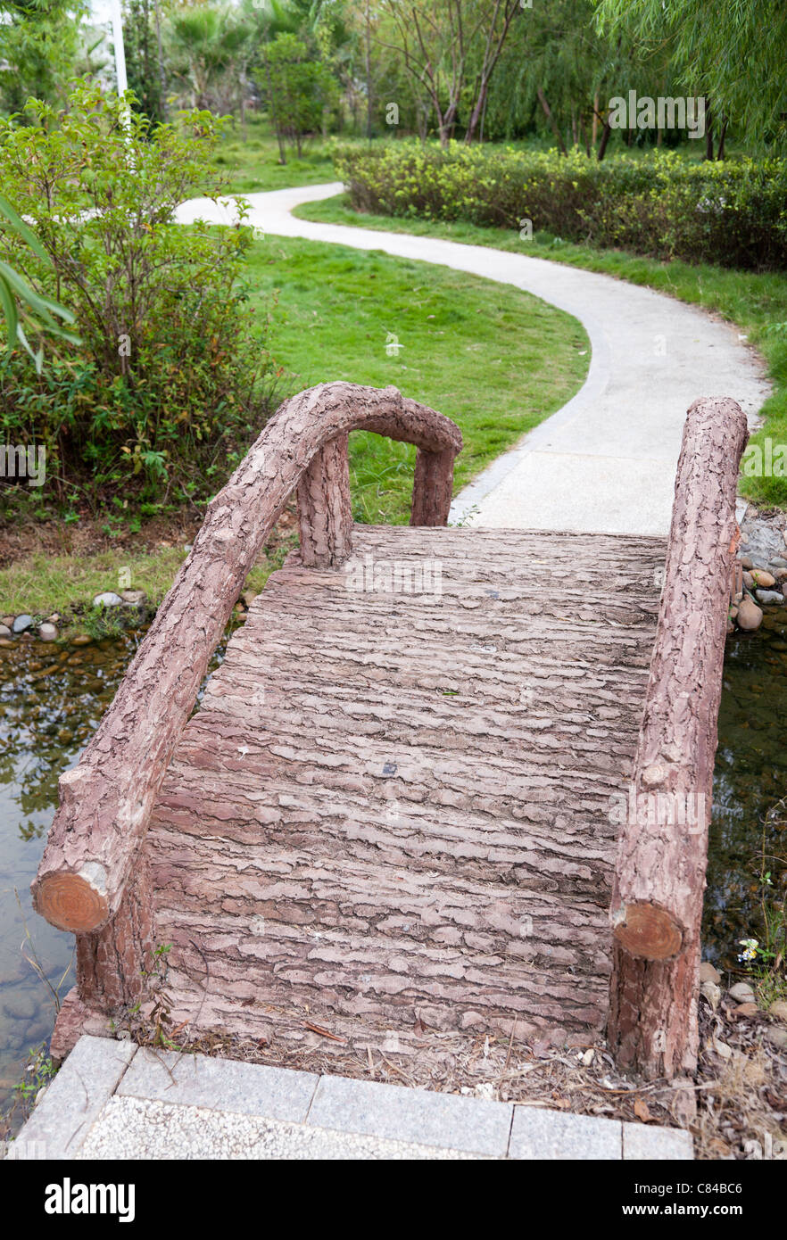 Garden with a stream through and footbridge on Stock Photo - Alamy
