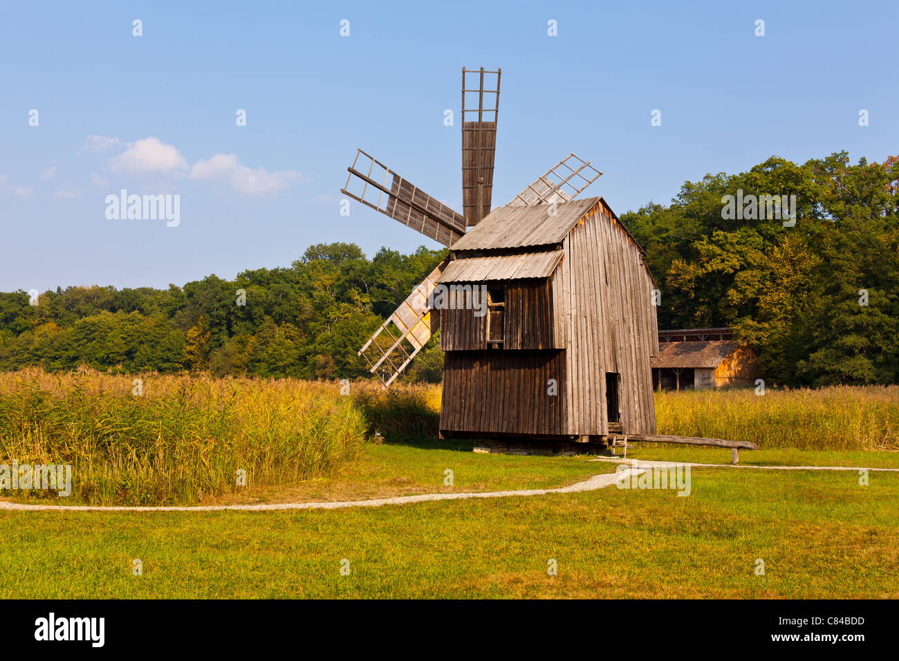 Ancient wind mill replica on a meadow at sunset Stock Photo - Alamy