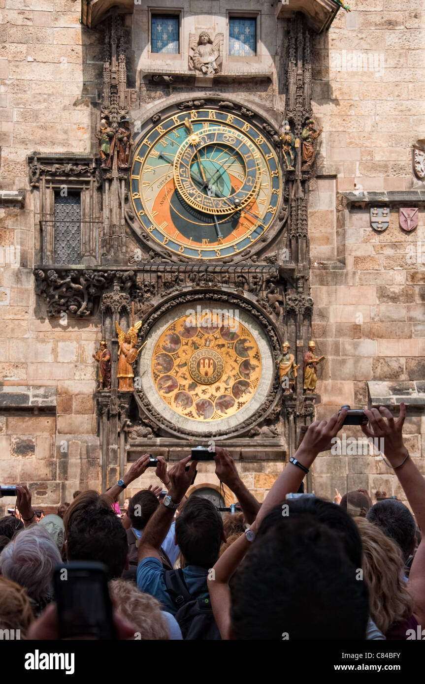 Tourists taking photos of old astronomical clock in the center square ...