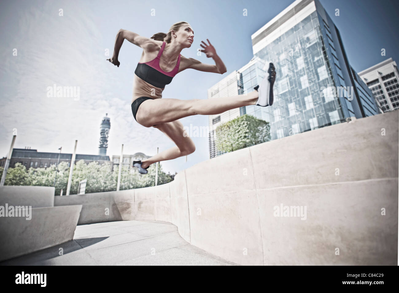 Athlete jumping over public sculpture Stock Photo - Alamy