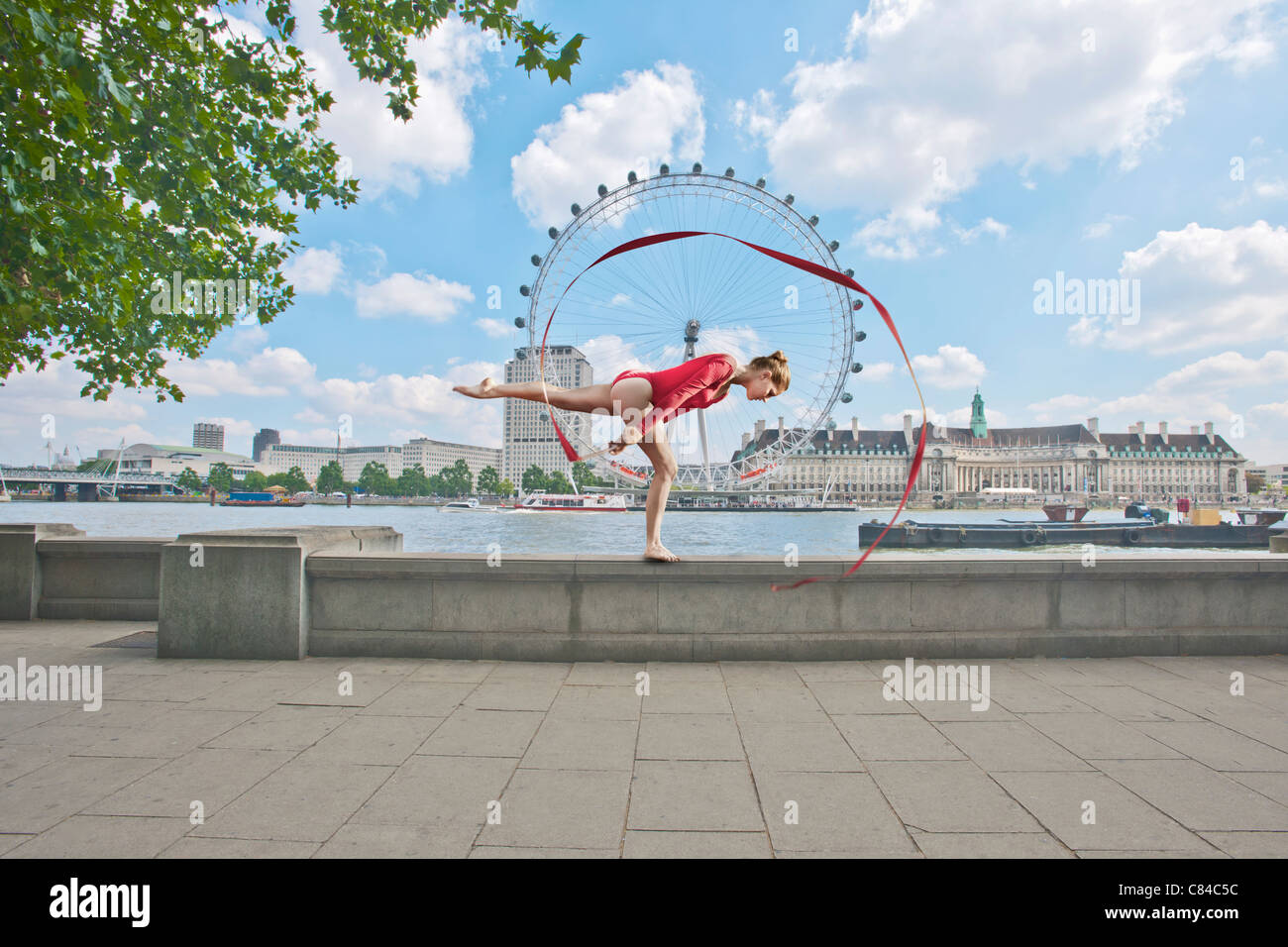 Gymnast twirling ribbon on city street Stock Photo - Alamy