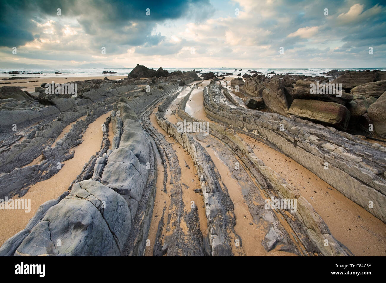 Curved stone formations on beach Stock Photo - Alamy