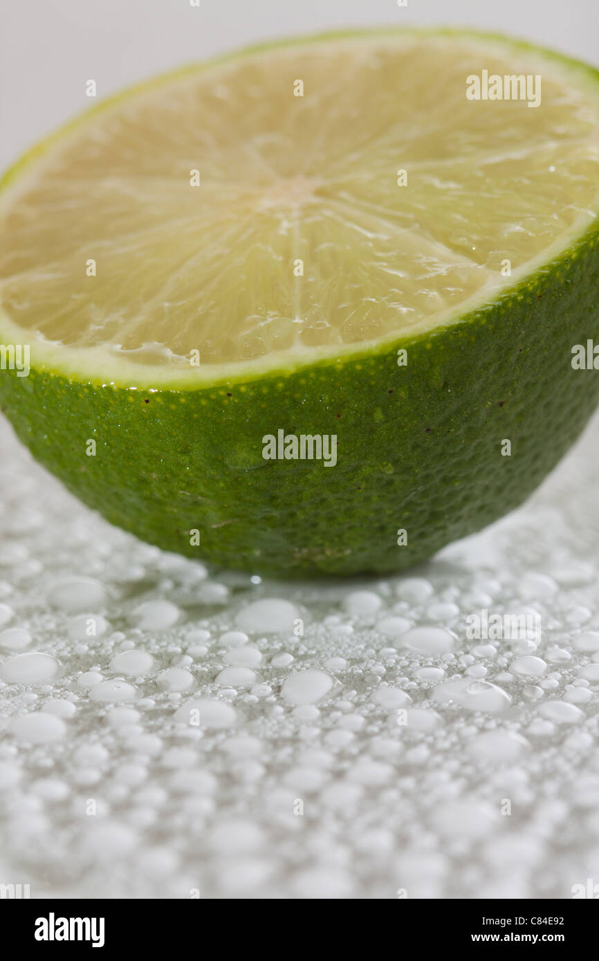 Lime with water drops on white Stock Photo - Alamy