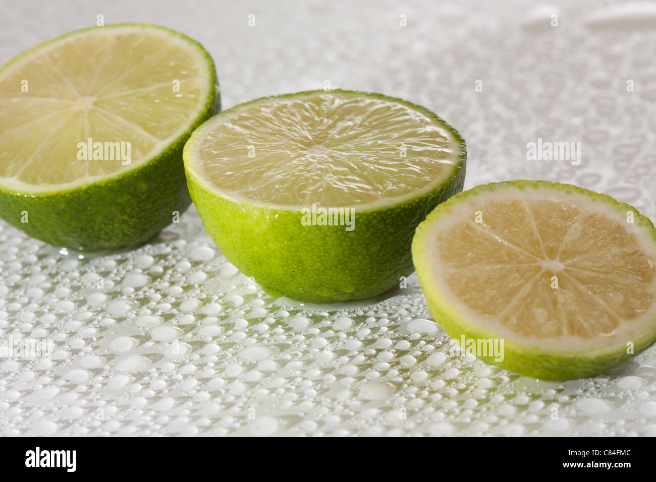 Lime with water drops on white Stock Photo - Alamy