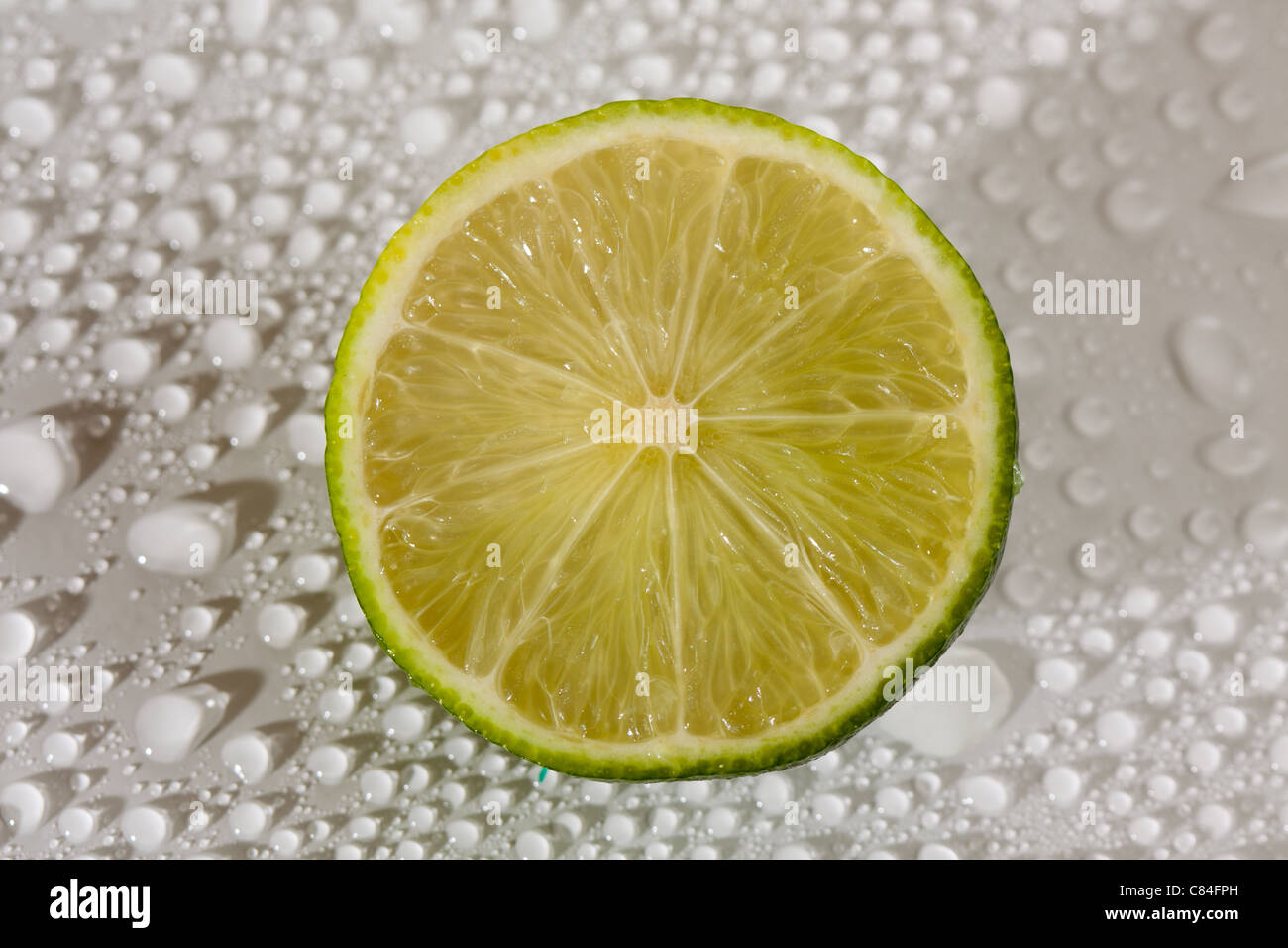 Lime with water drops on white Stock Photo - Alamy