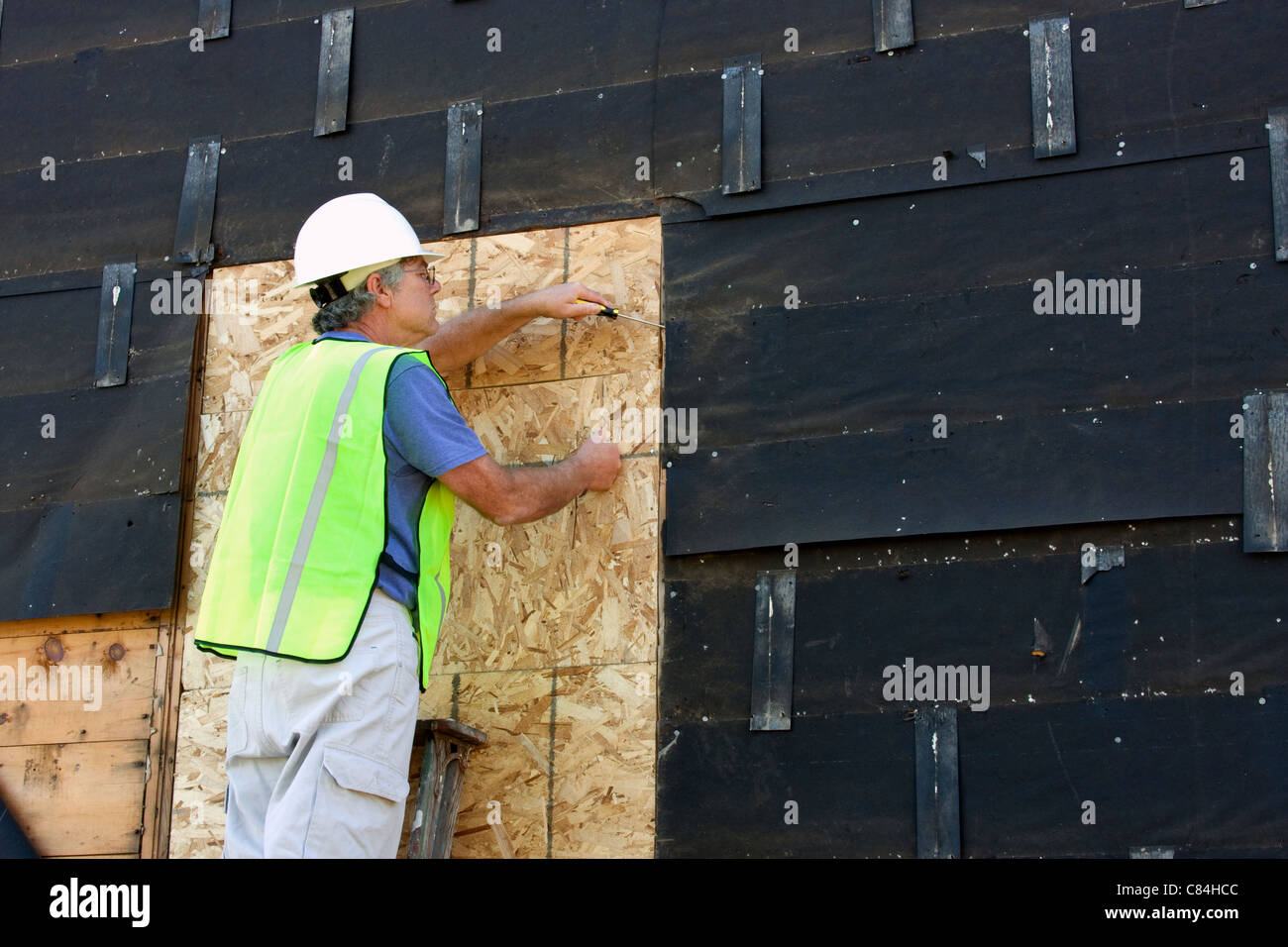 carpenter on a ladder doing construction to a house Stock Photo - Alamy