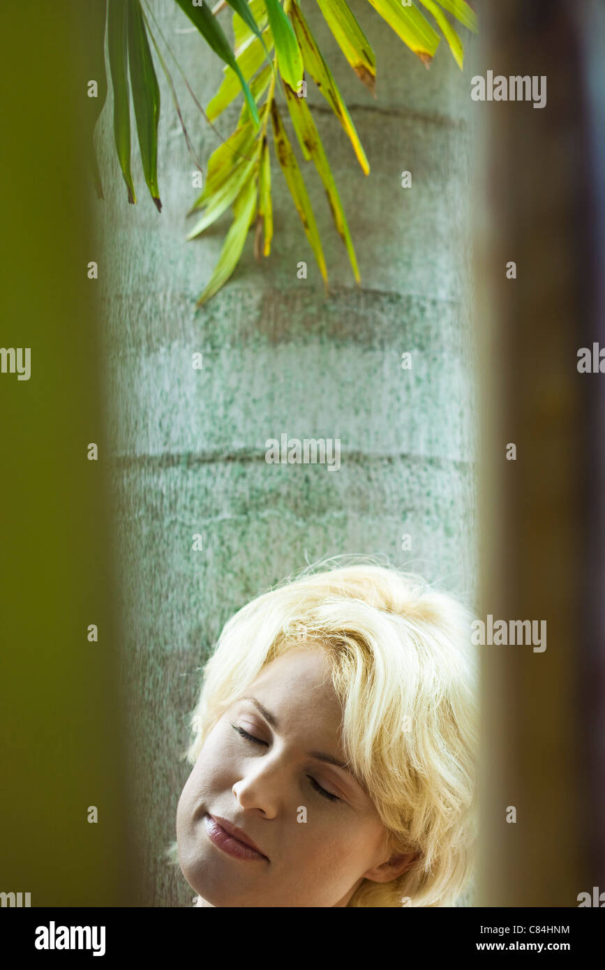 Woman relaxing under palm tree Stock Photo - Alamy