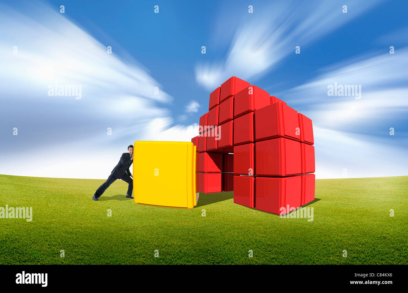 A man pushing the yellow box into other piled red boxes Stock Photo - Alamy