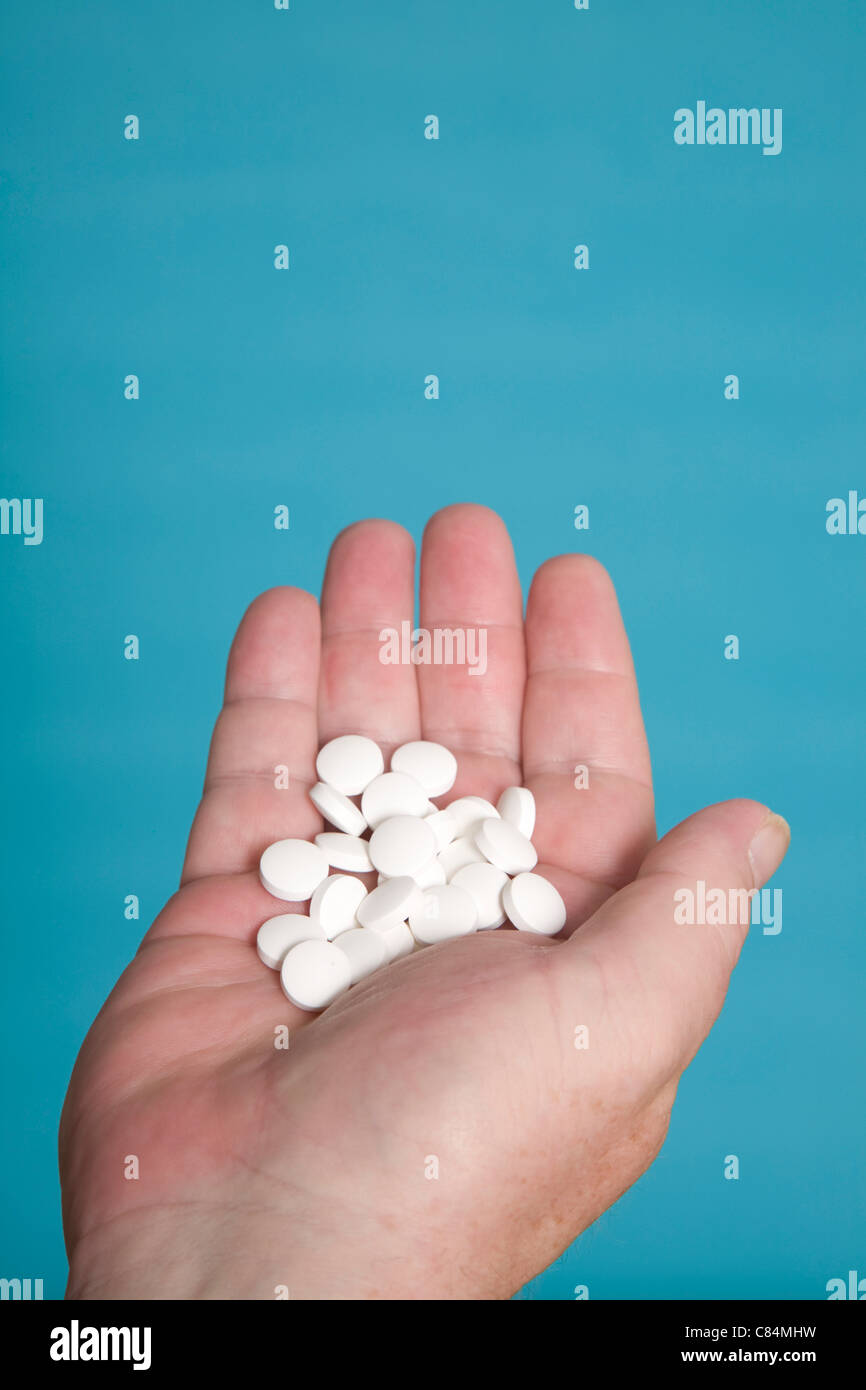 Hand holding a bunch of white medicine tablets Stock Photo - Alamy