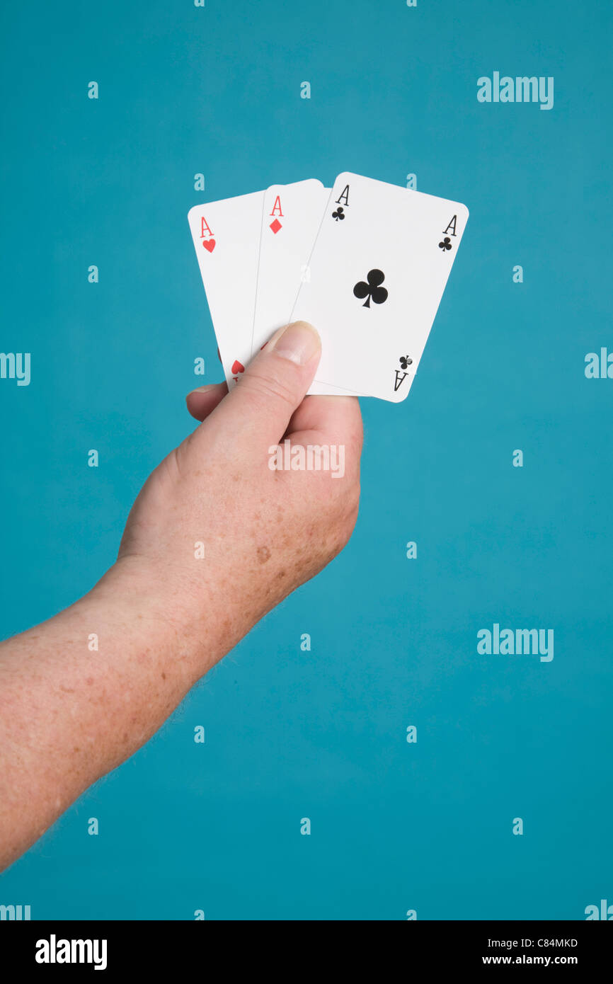 Hand holding playing cards of three Aces Stock Photo - Alamy