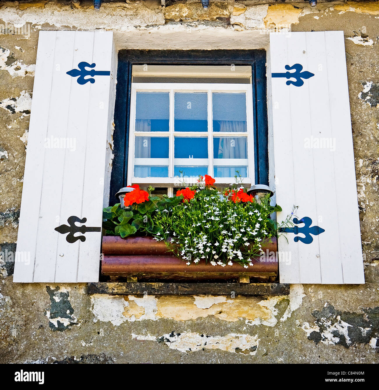 Sash window in a Cornish cottage with artificial wooden shutters and ...
