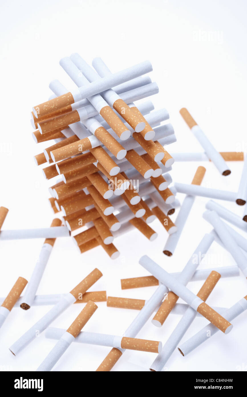 Stacked cigarettes with other scatted cigarettes around Stock Photo - Alamy