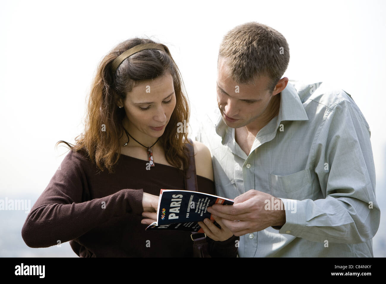 Tourist couple consulting guidebook Stock Photo - Alamy
