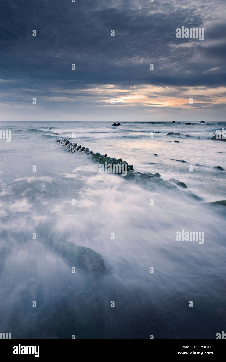 Waves washing over rocks on beach Stock Photo - Alamy