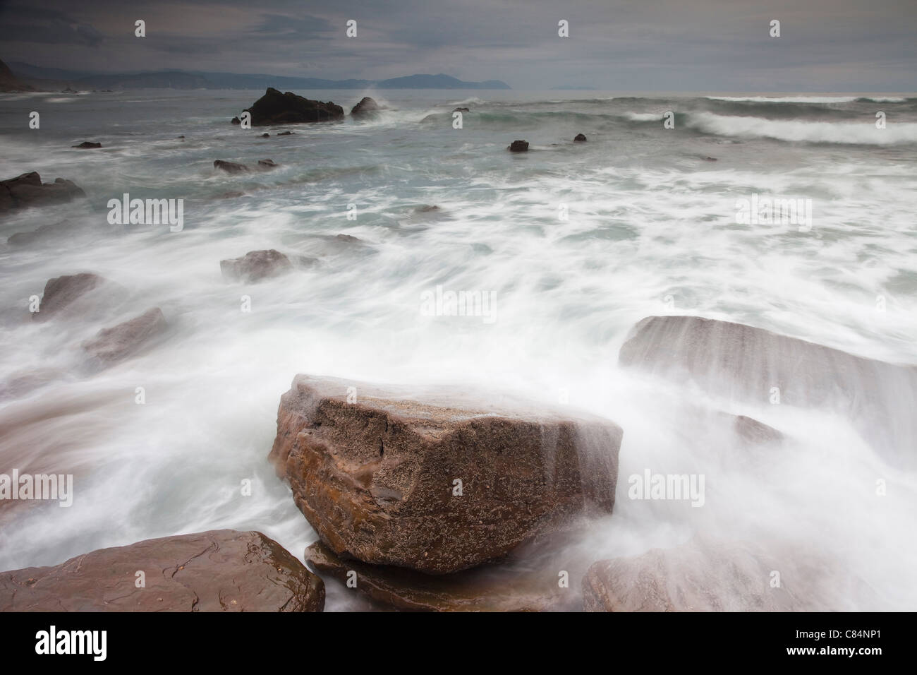 Waves washing over rocks on beach Stock Photo - Alamy