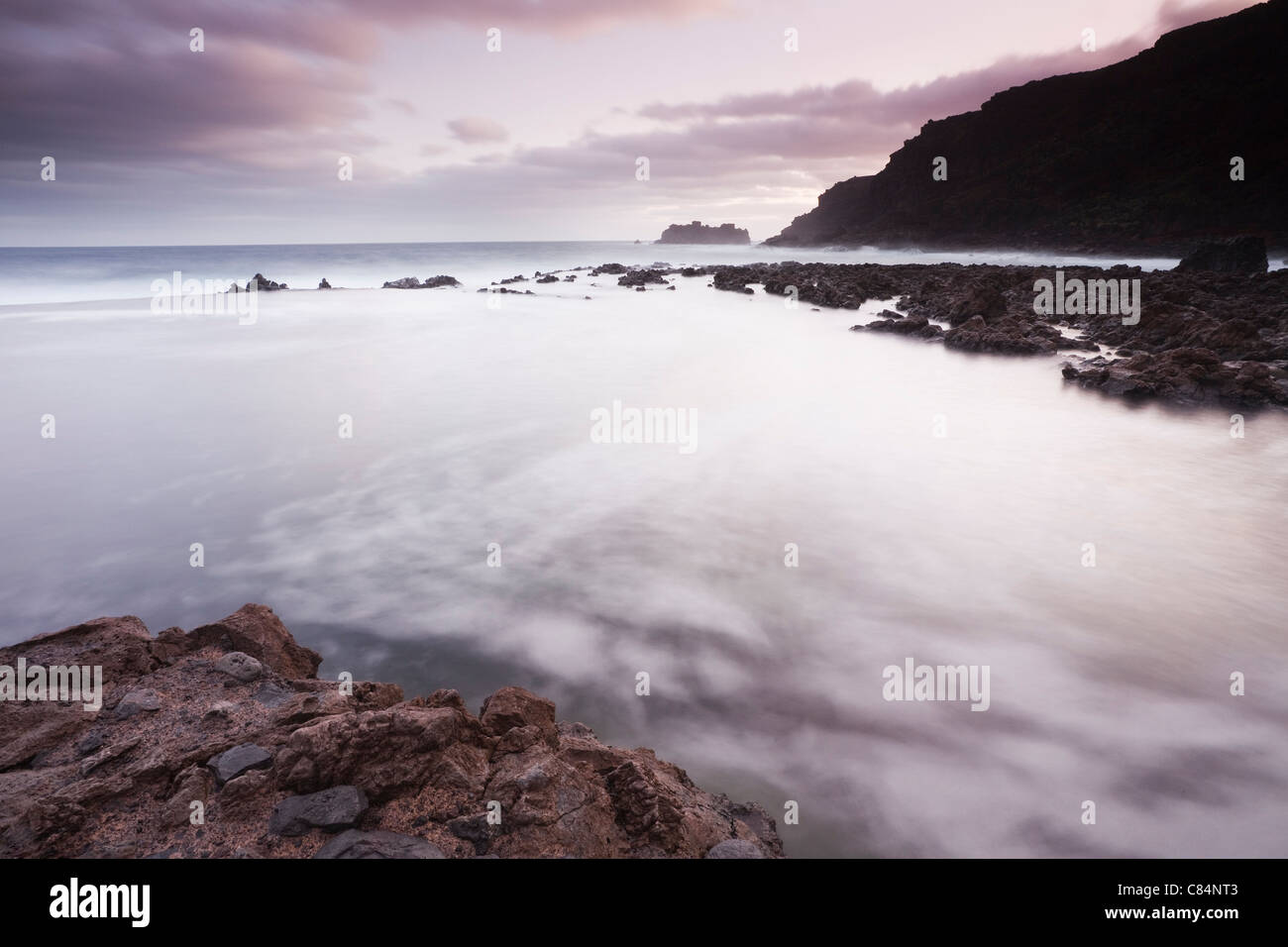 Waves washing over rocks on beach Stock Photo - Alamy