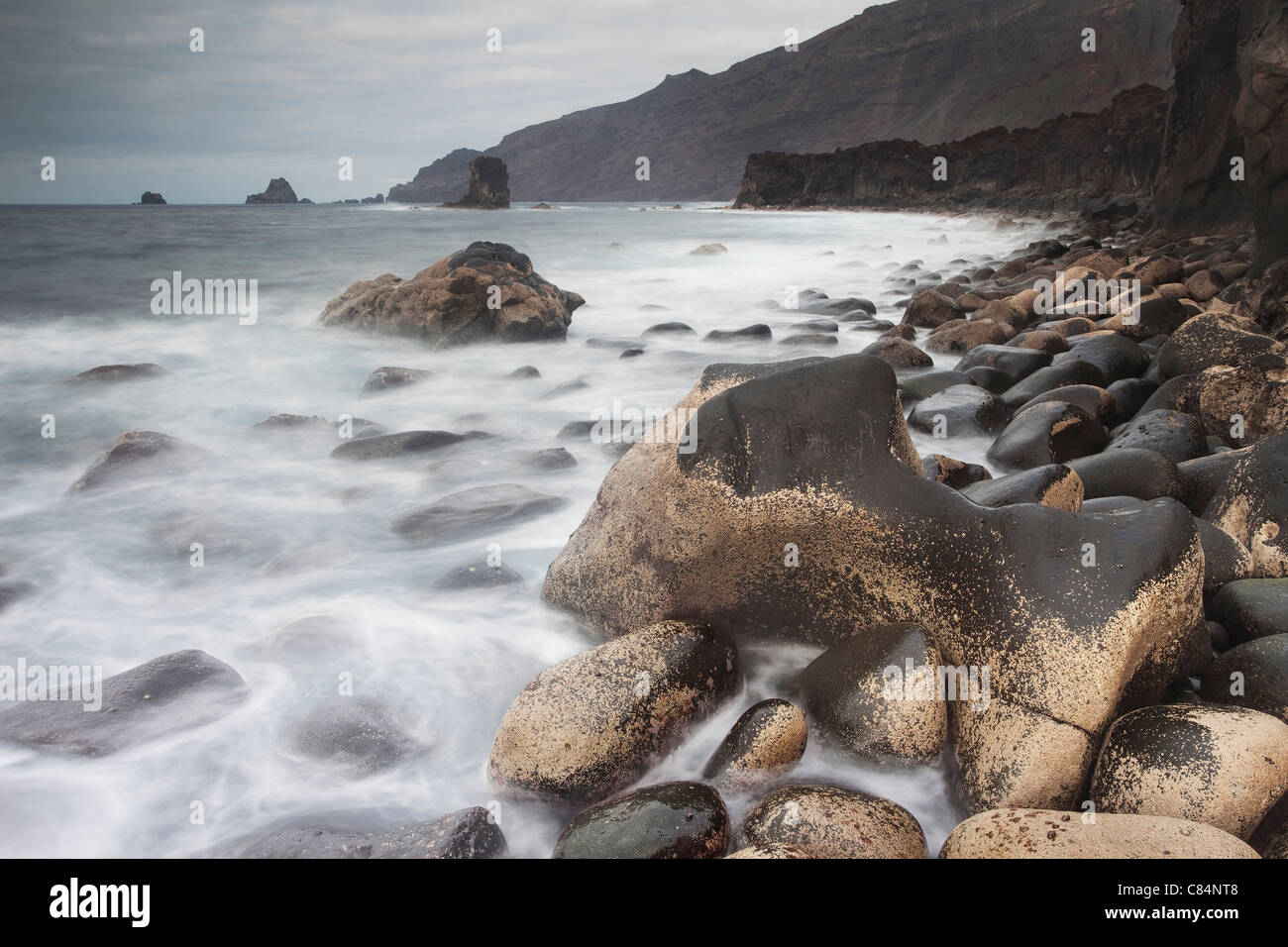 Waves washing over rocks on beach Stock Photo - Alamy