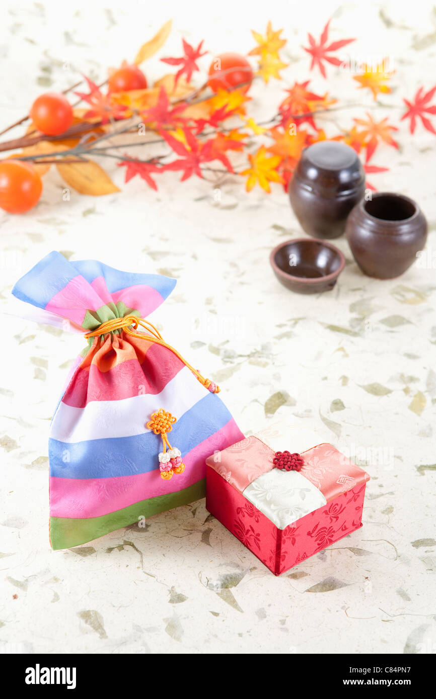 Traditonal lucky bag and box with jars and colored leaves behind Stock ...