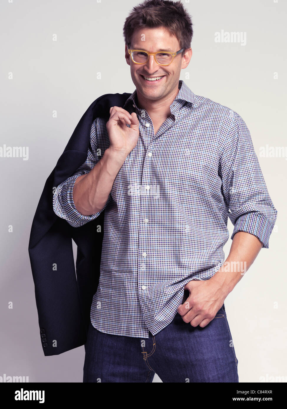 Fashionably dressed smiling man in his thirties wearing jeans and a ...