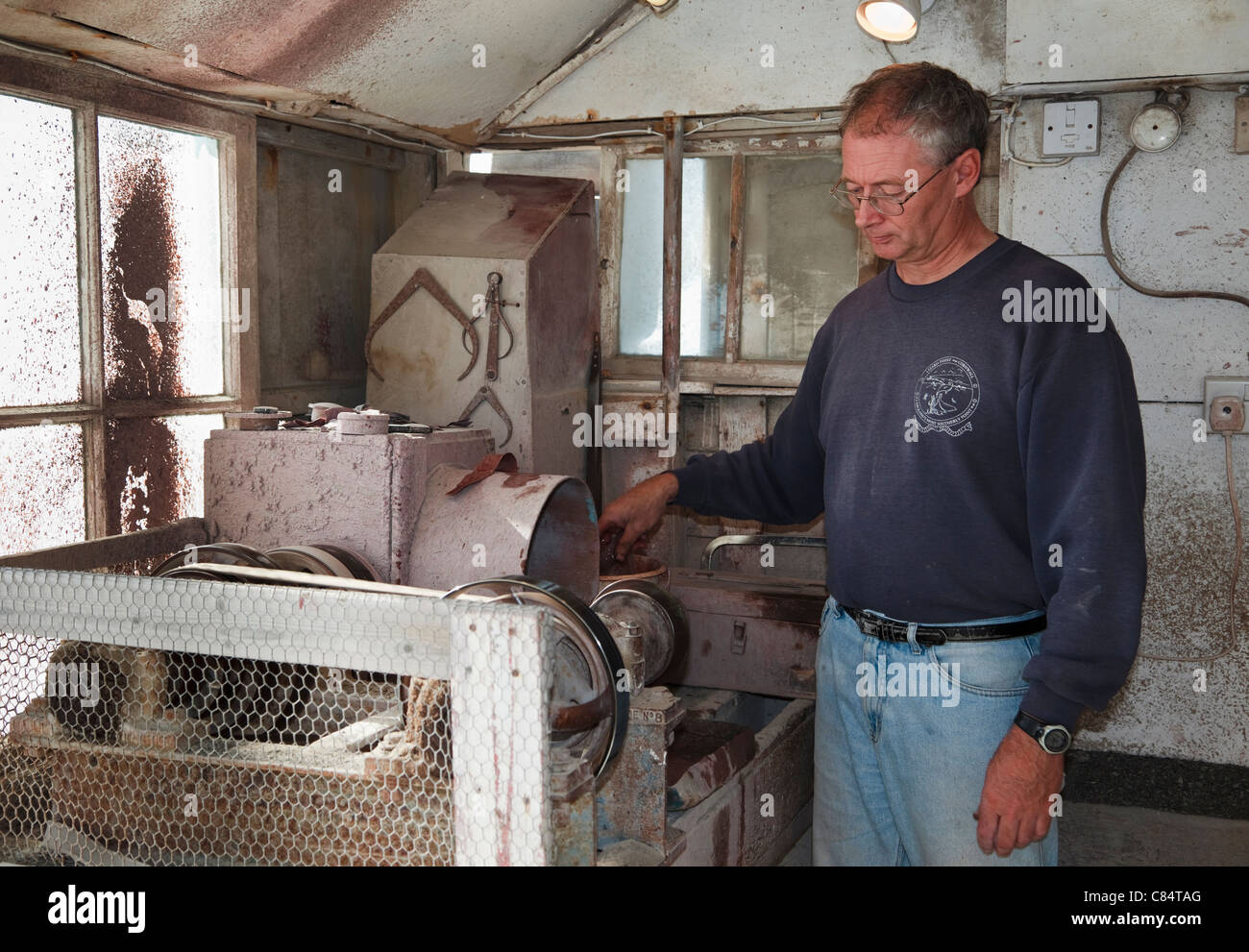 Local craftsman Ian Casley hand turning serpentine stone on machinery ...