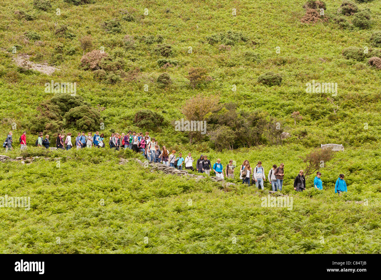 A group of students on a study trip walking along a footpath in the ...