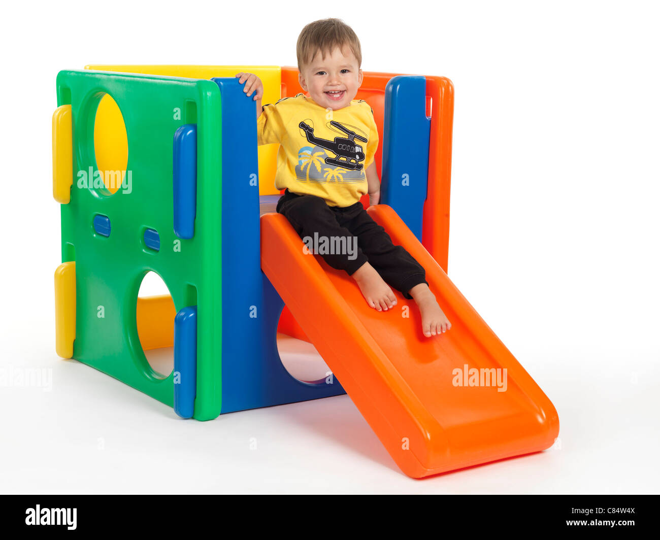 Happy one and a half year old child on a slide. Isolated on white ...