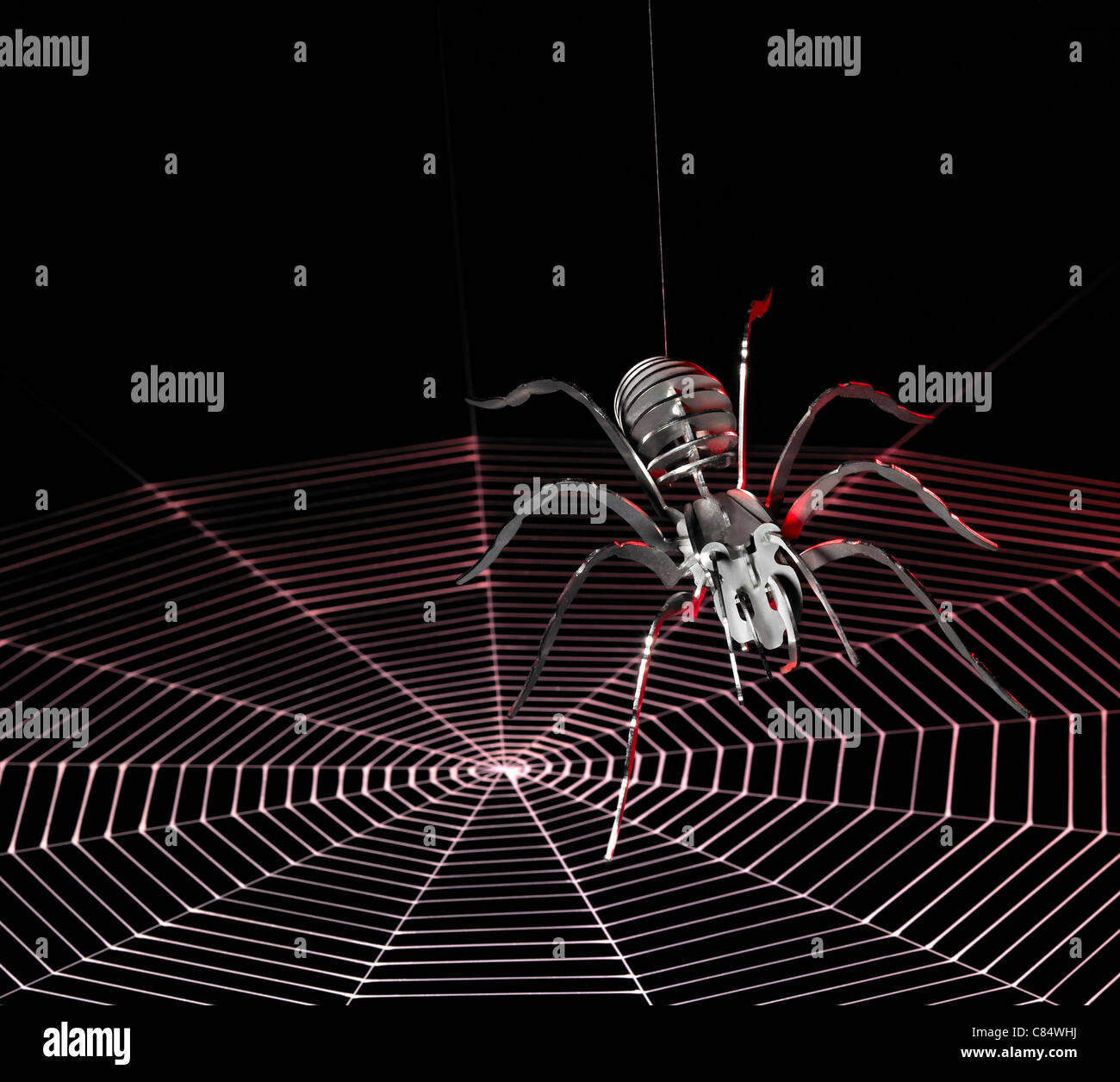 a simplified spider made of metal and a artificial spiderweb. Red ...