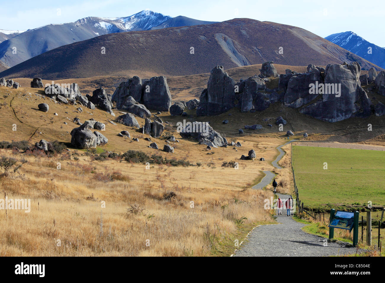 Tourists walking along the path toward the strange limestone rock ...