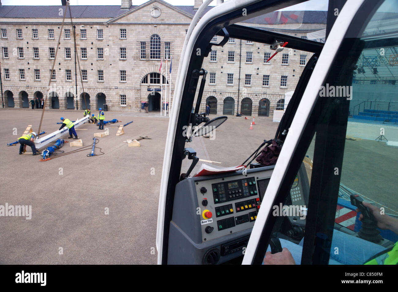 driver of crane views workmen below attaching crane arm Stock Photo - Alamy