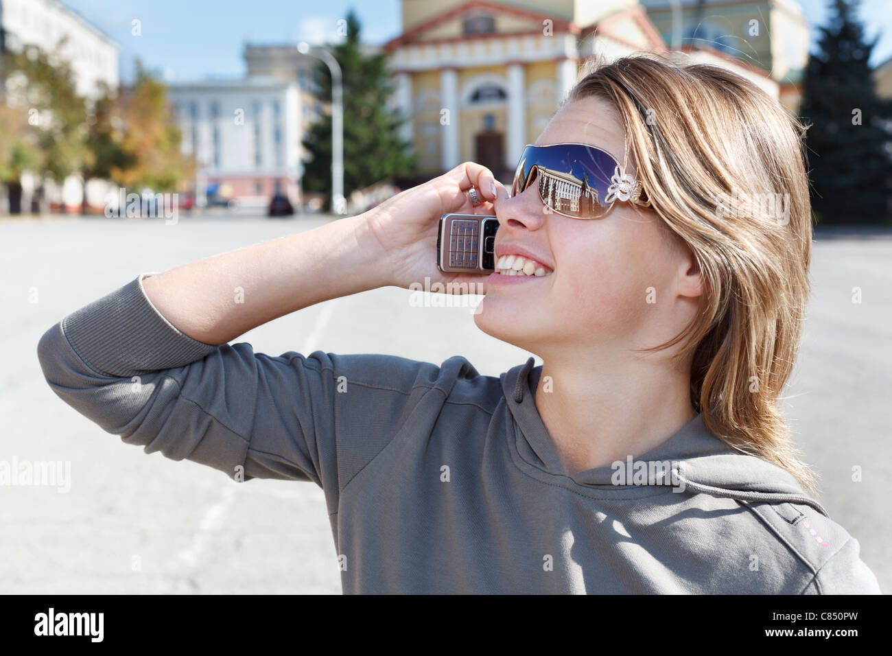 Young Russian beautiful girl calling by mobile phone outdoors. Summer ...