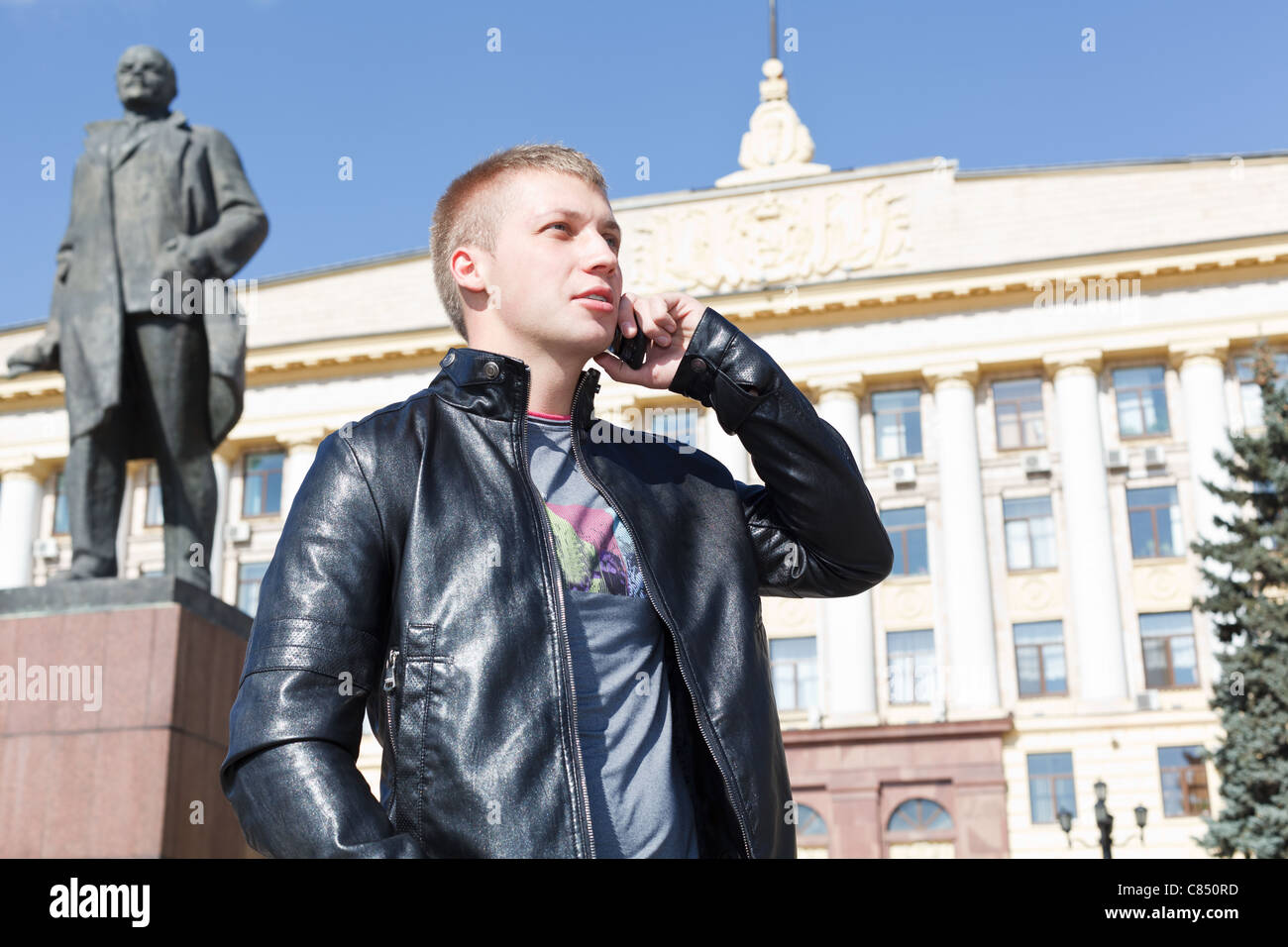 Young Russian handsome male on the mobile phone ringing outdoors near ...