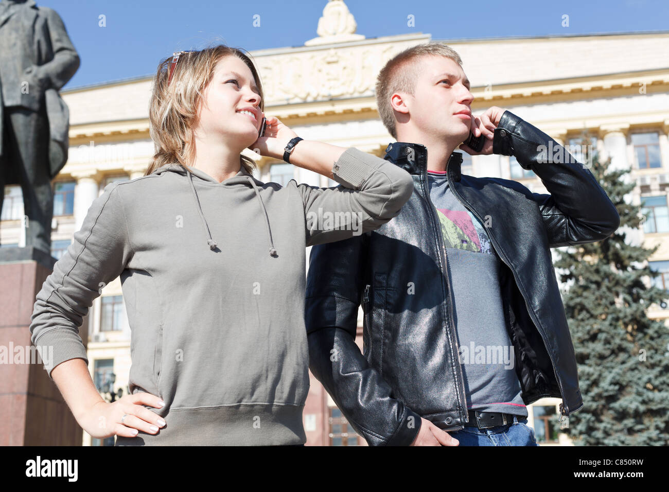 Young Russian beautiful woman and man talking by the mobile phone ...