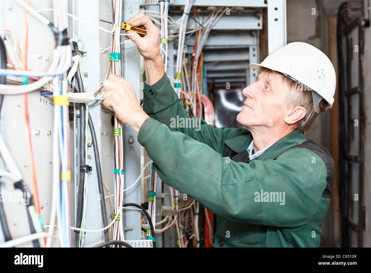 Professional electrician working alone in hi-res stock photography and ...