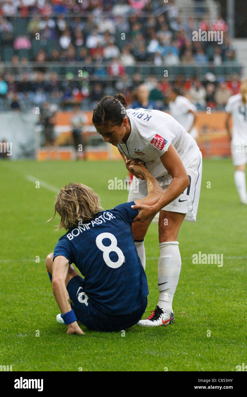 Alex Krieger of the United States (R) helps Sonia Bompastor of France ...
