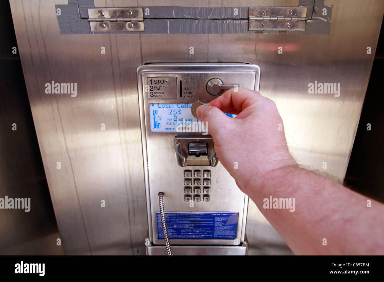 Hand placing a US Quarter into a pay telephone Stock Photo - Alamy