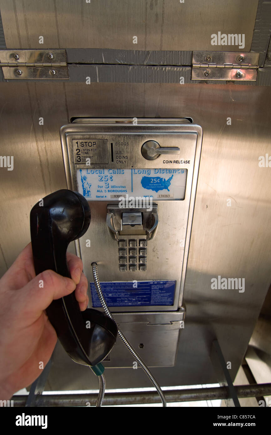 Hand holding public telephone receiver Stock Photo - Alamy