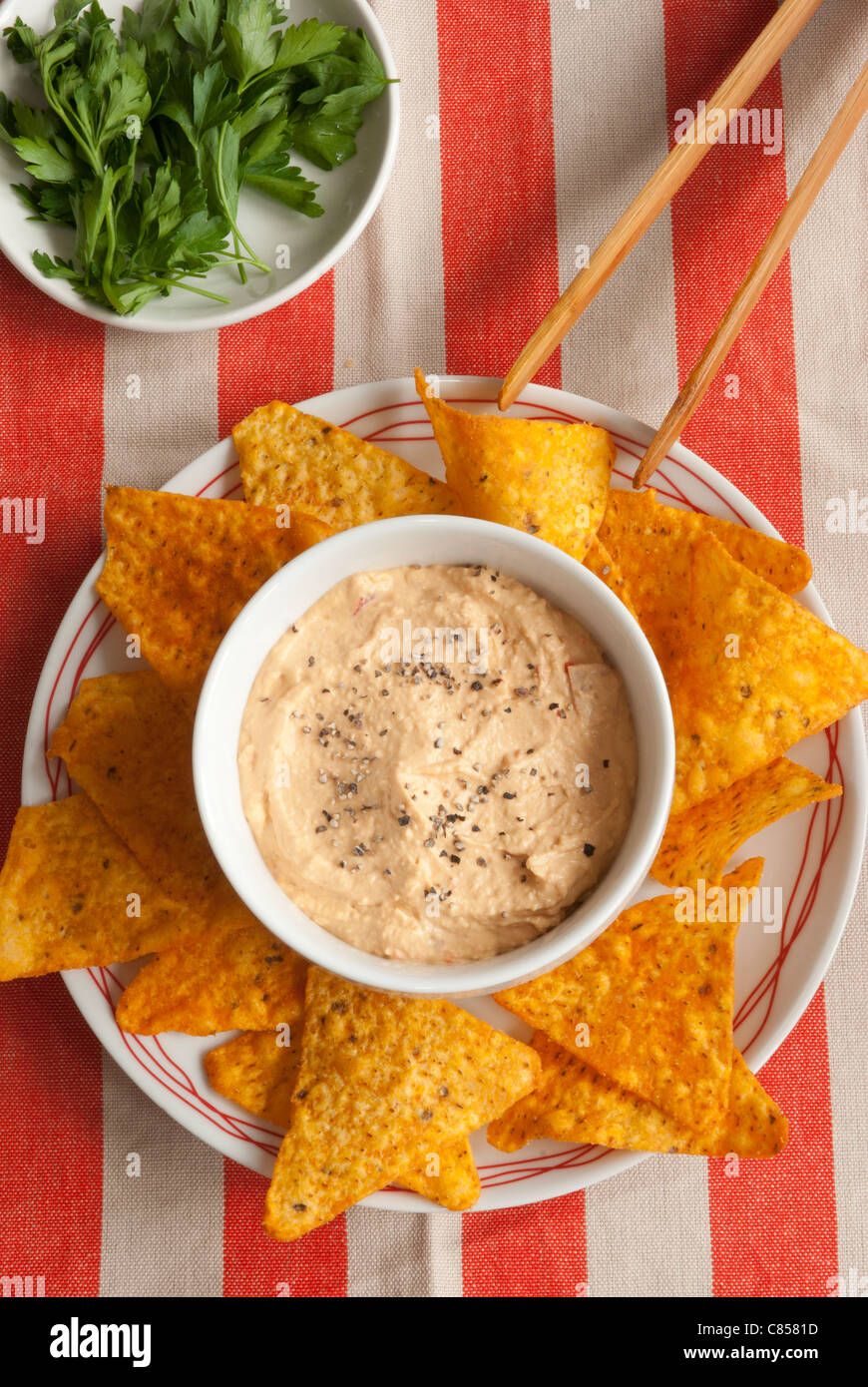 Tortilla crisps with red pepper houmous Stock Photo - Alamy