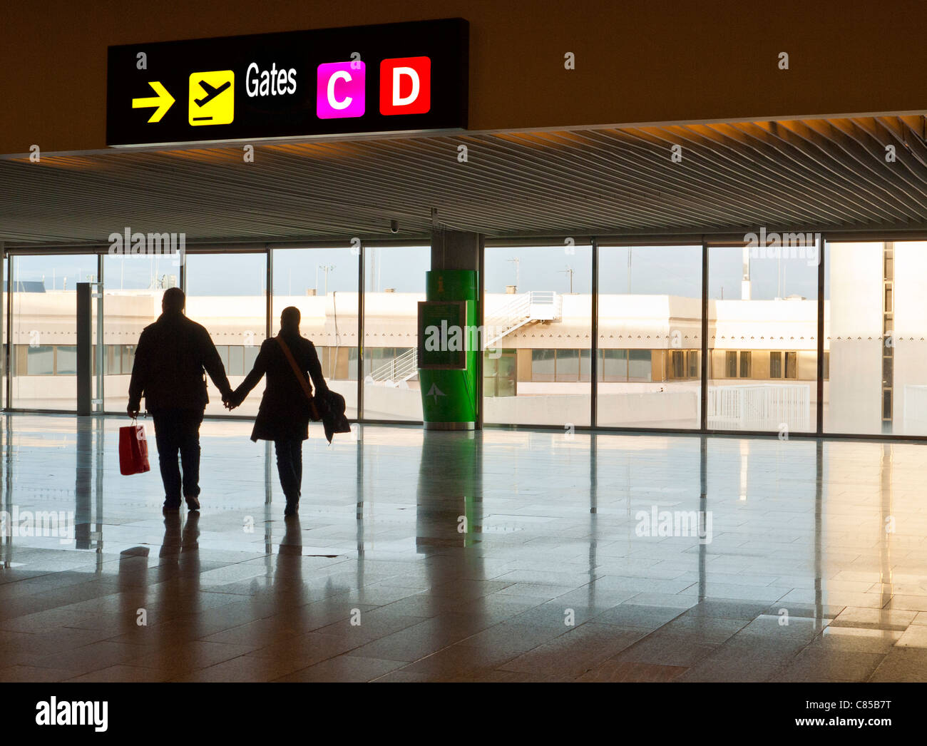 Romantic couple with duty free shopping bags walking hand in hand to ...