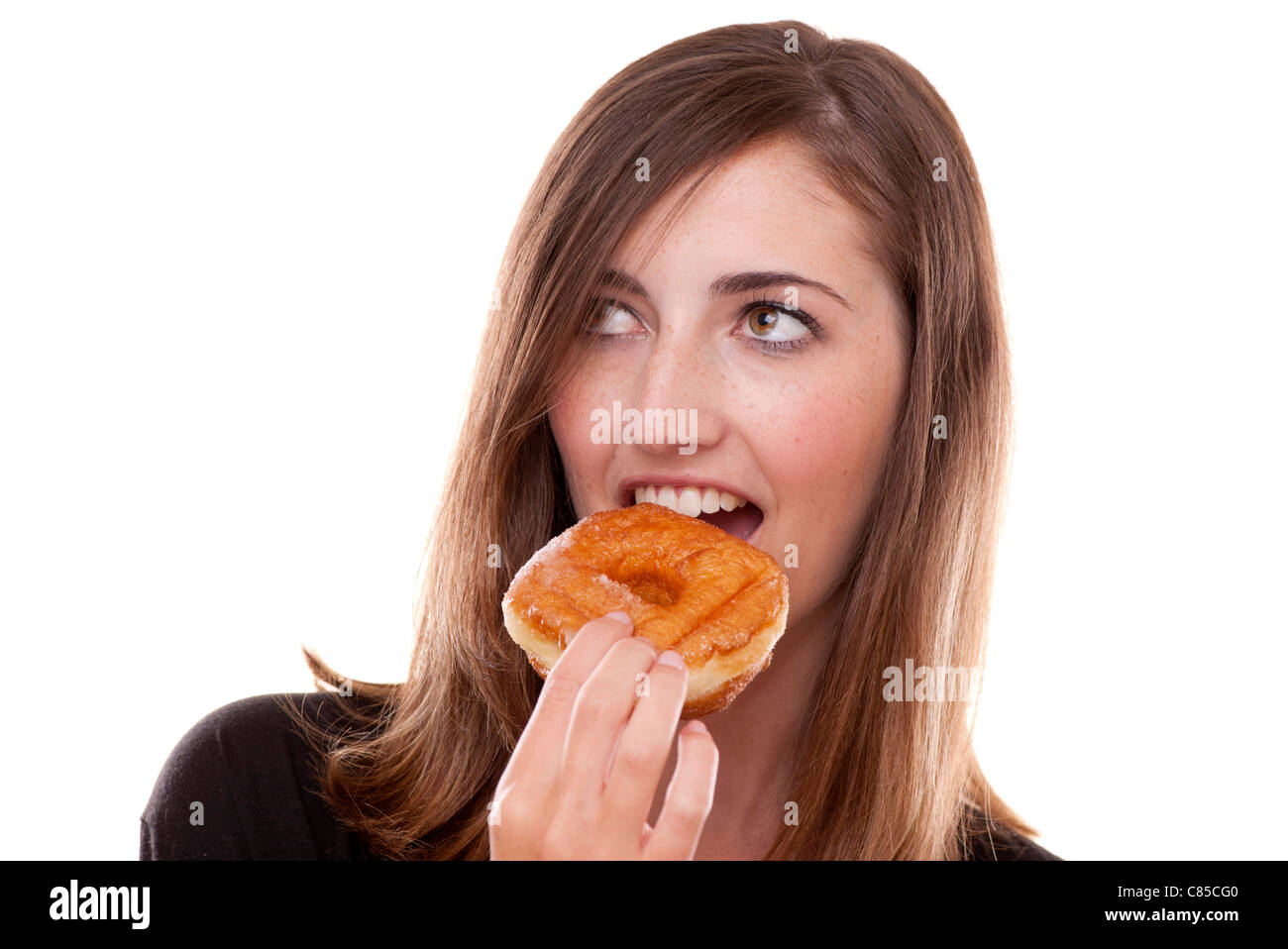 young woman eating biting into a doughnut Stock Photo - Alamy