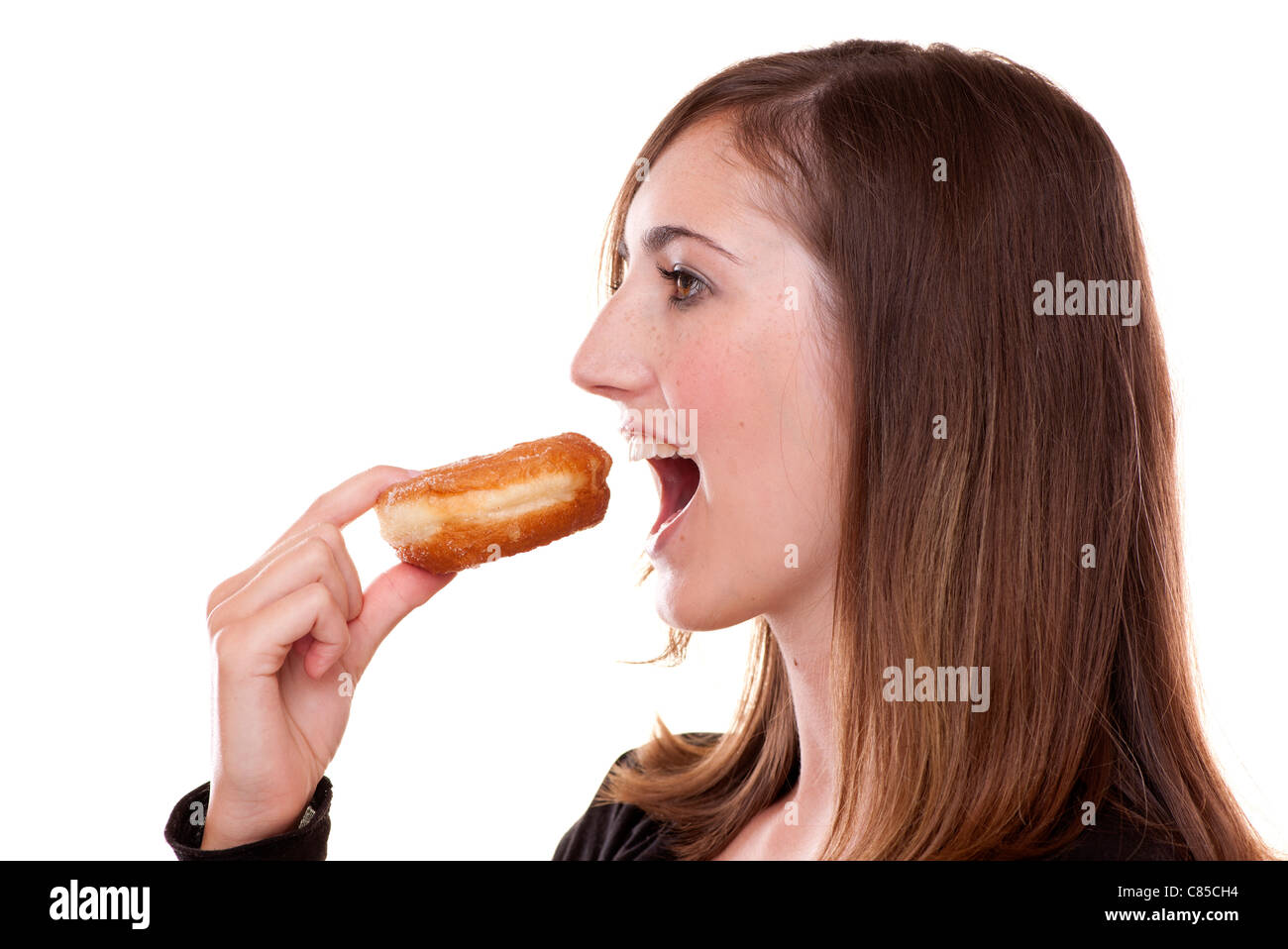 young woman eating biting into a doughnut Stock Photo - Alamy